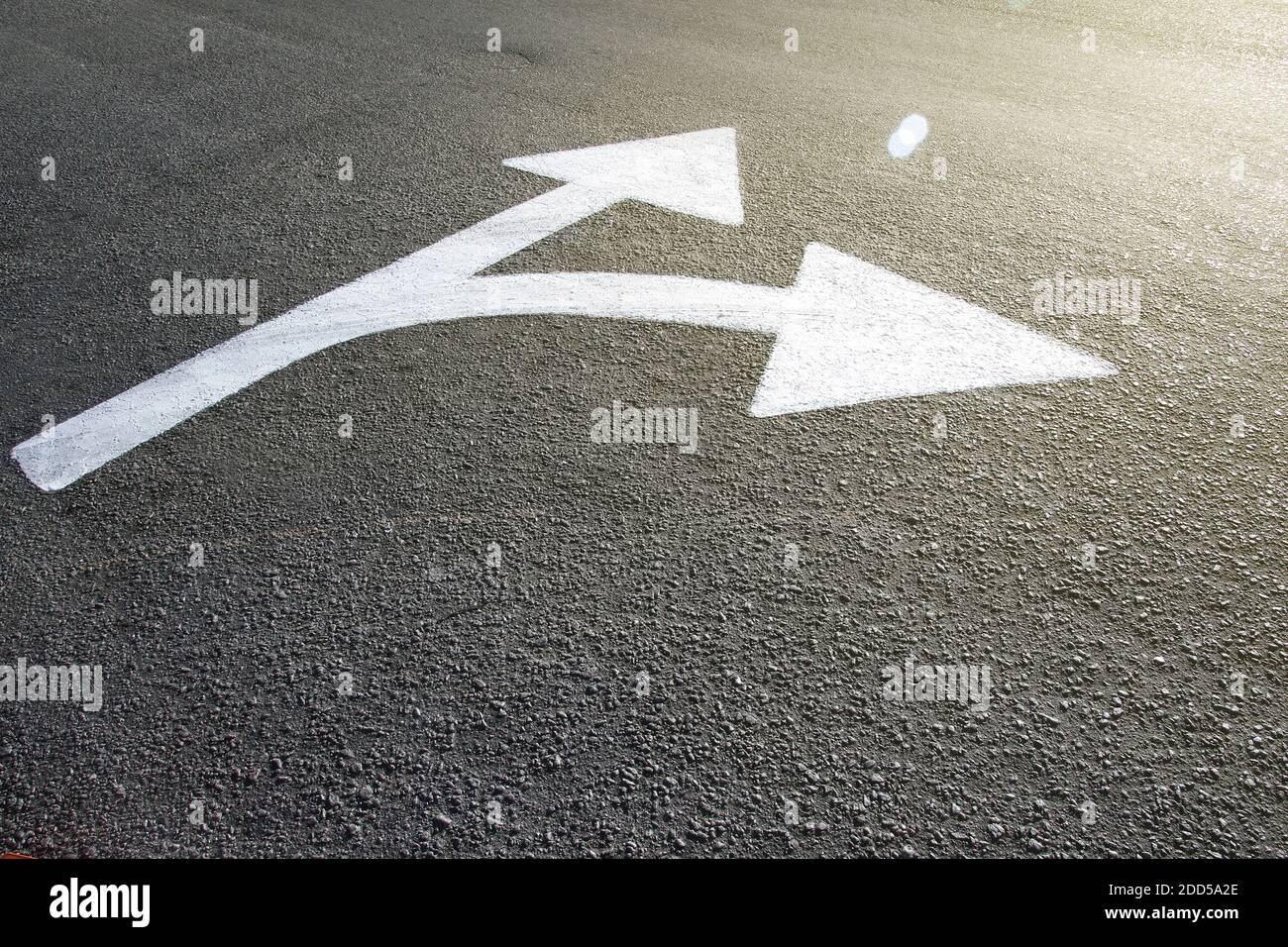 white directional arrow drawn on the asphalt ground - concept of paths ...