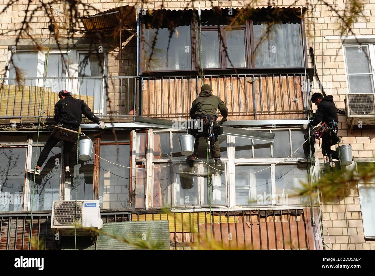 Workers repair facade of house building Stock Photo - Alamy
