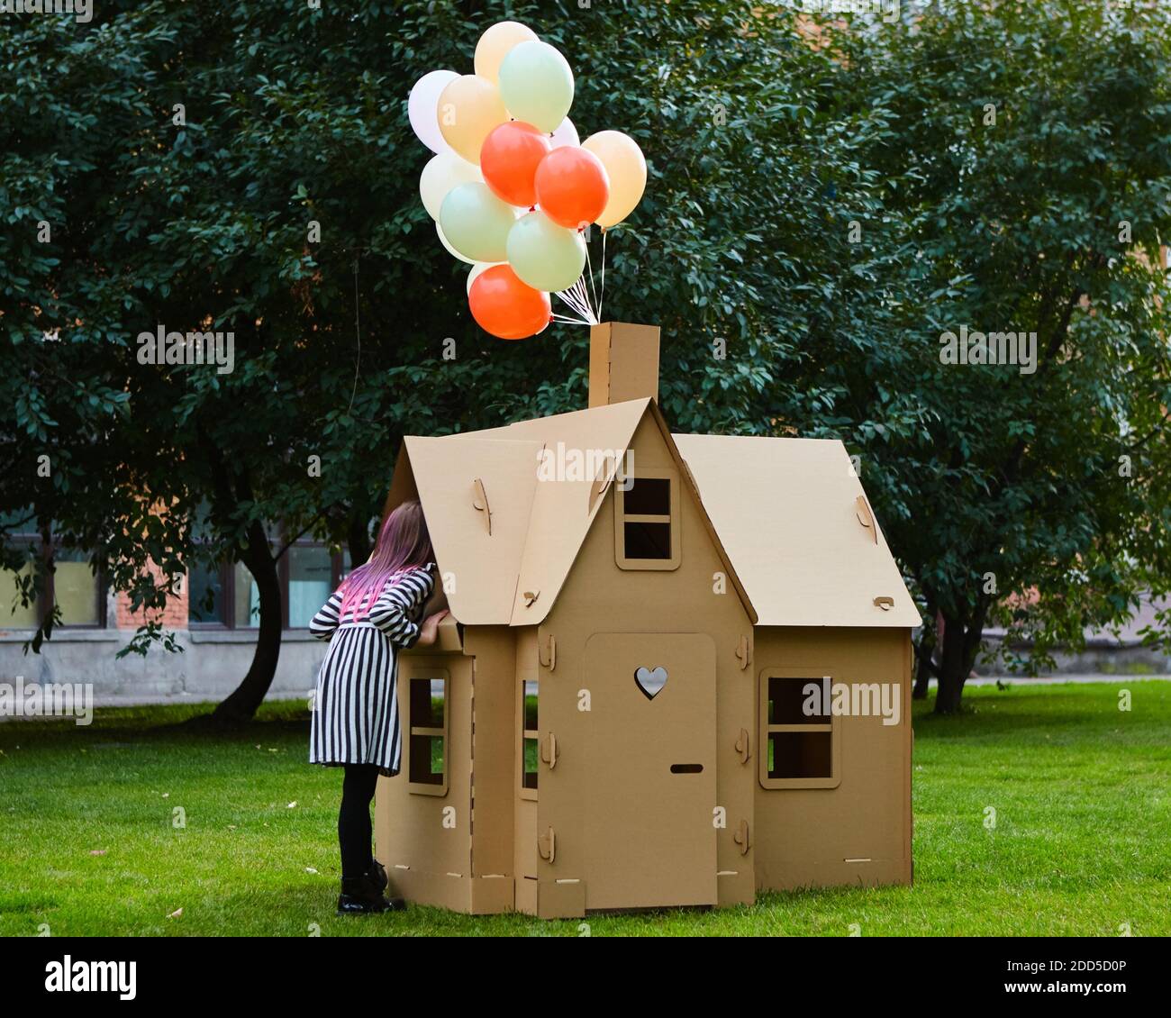 Child playing in a cardboard playhouse. Eco concept Stock Photo - Alamy