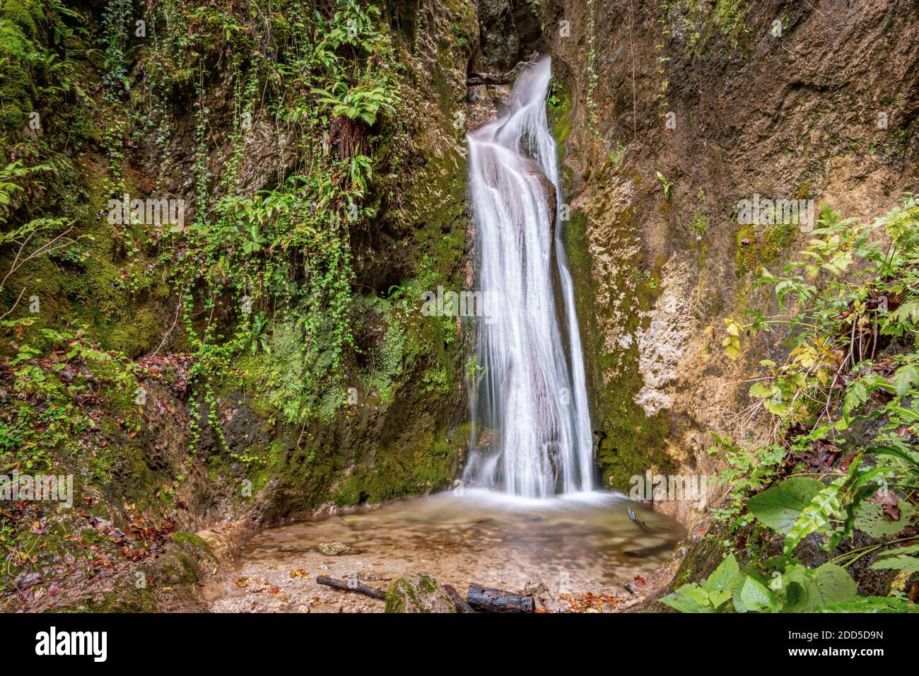Landscape view of a colorful waterfall and small basin at bottom ...