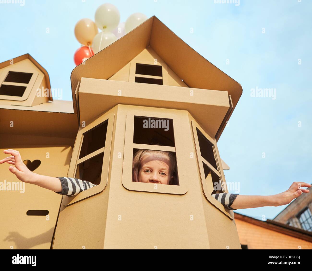 Child playing in a cardboard playhouse. Eco concept Stock Photo - Alamy