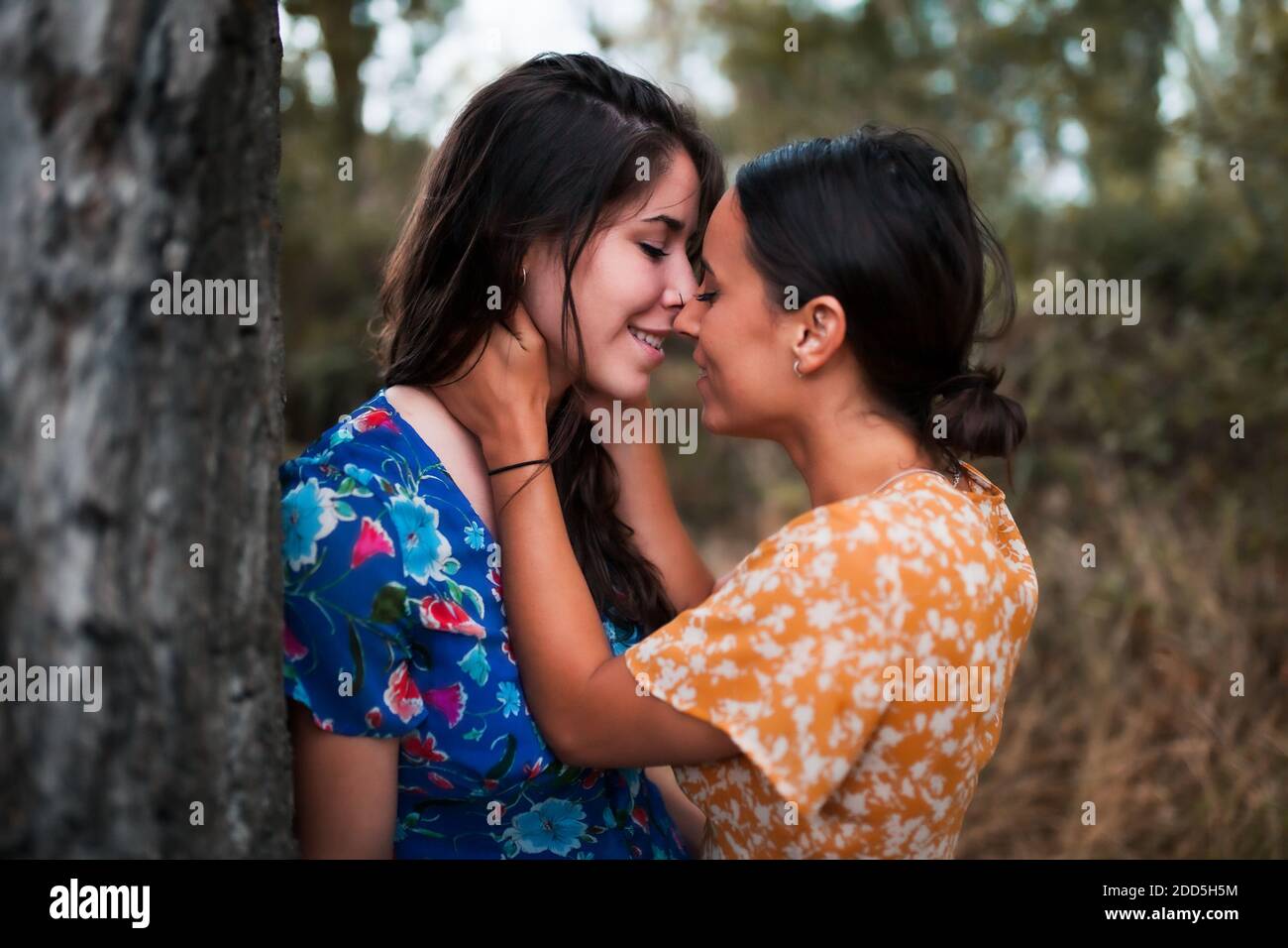 Two young lesbians kissing and caressing each other in the woods Stock Photo - Alamy
