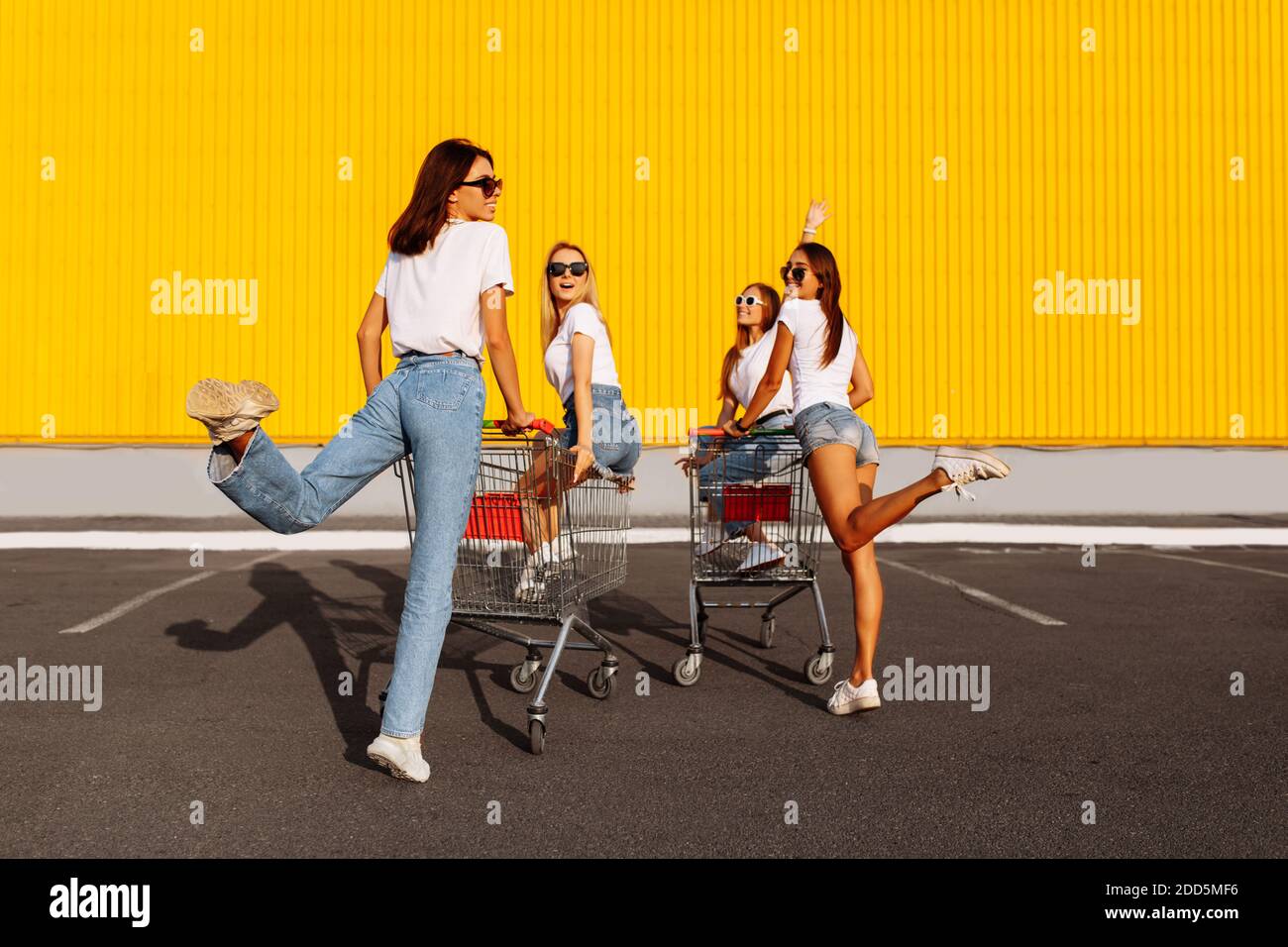 happy young women in casual clothes, friends having fun and riding in a ...