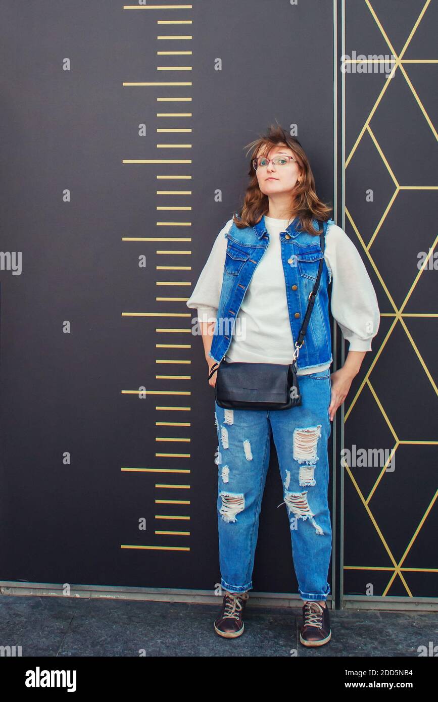 woman stands next to a large scale ruler. Measurement of a woman in ...