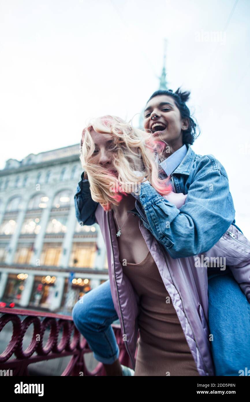 Two teenage girls infront of university building smiling, having fun ...
