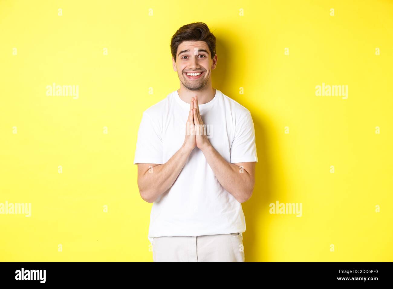 Hopeful man asking for help, begging favour, need something and smiling ...