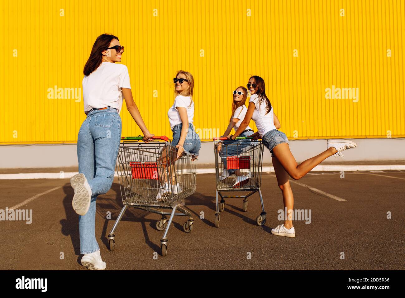 Group young friends, young women having fun, ride on carts on a summer ...