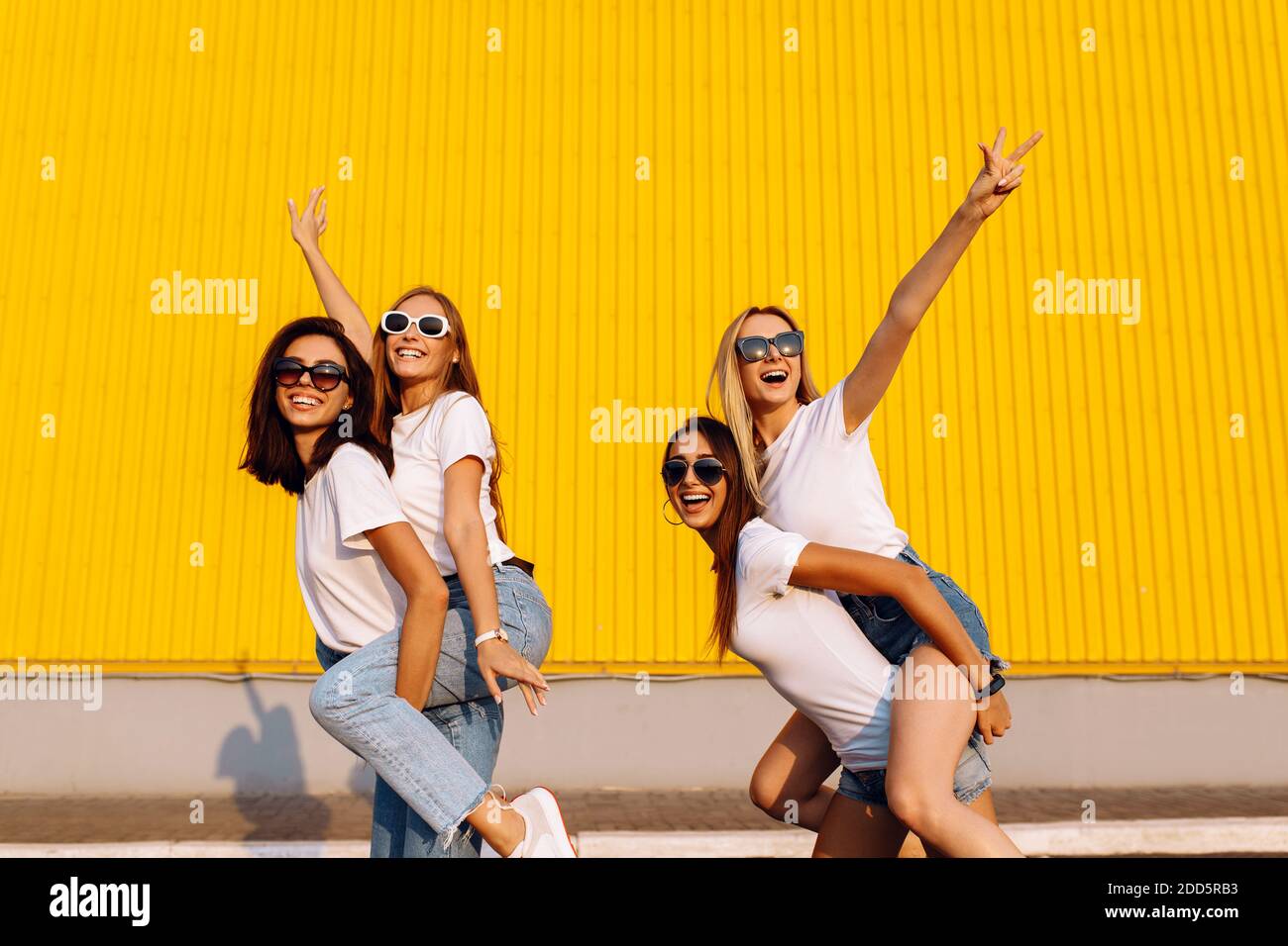 excited friends having fun outdoors rolling each other on their backs ...