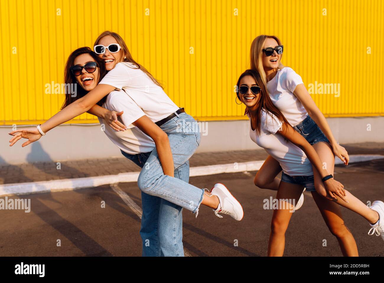 Young excited friends having fun outdoors rolling each other on their ...