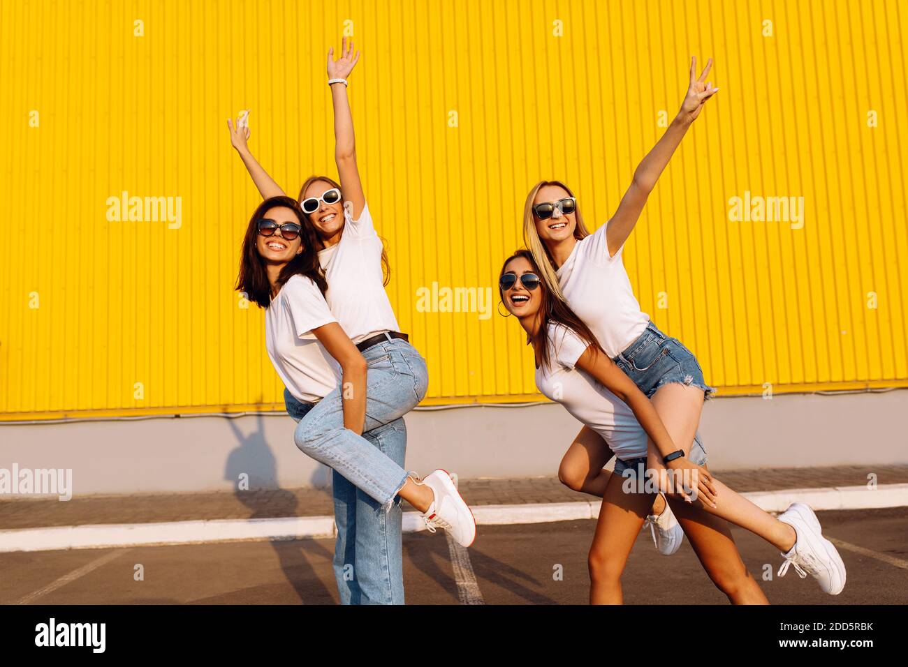 Young excited friends having fun outdoors rolling each other on their ...