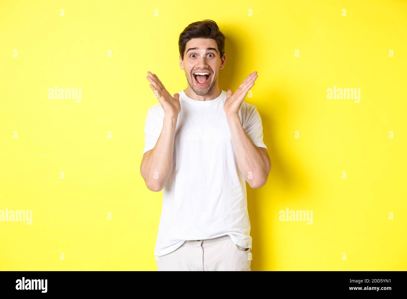 Surprised and happy man reacting to announcement, smiling and looking ...