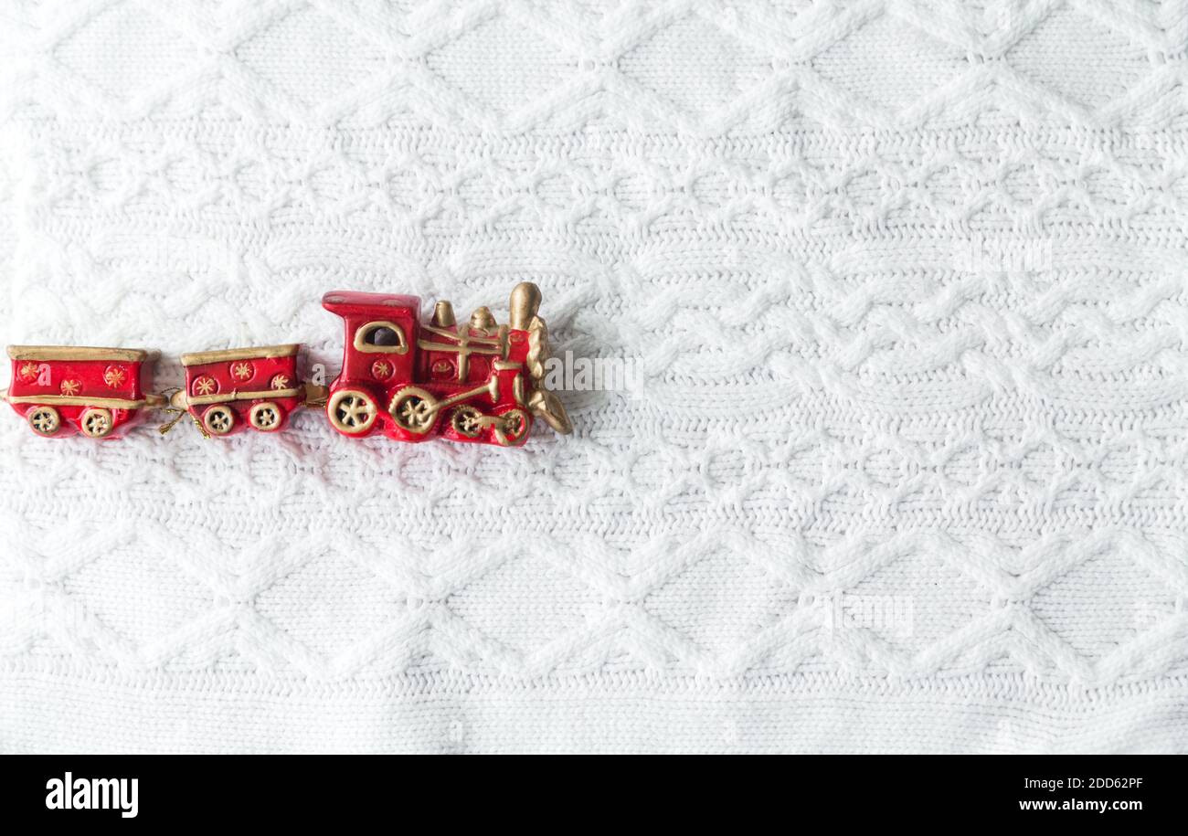 Toy steam locomotive of red color on a white knitted background Stock ...