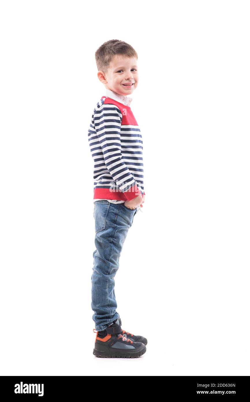 Side view of cute happy young boy smiling and looking at camera with ...