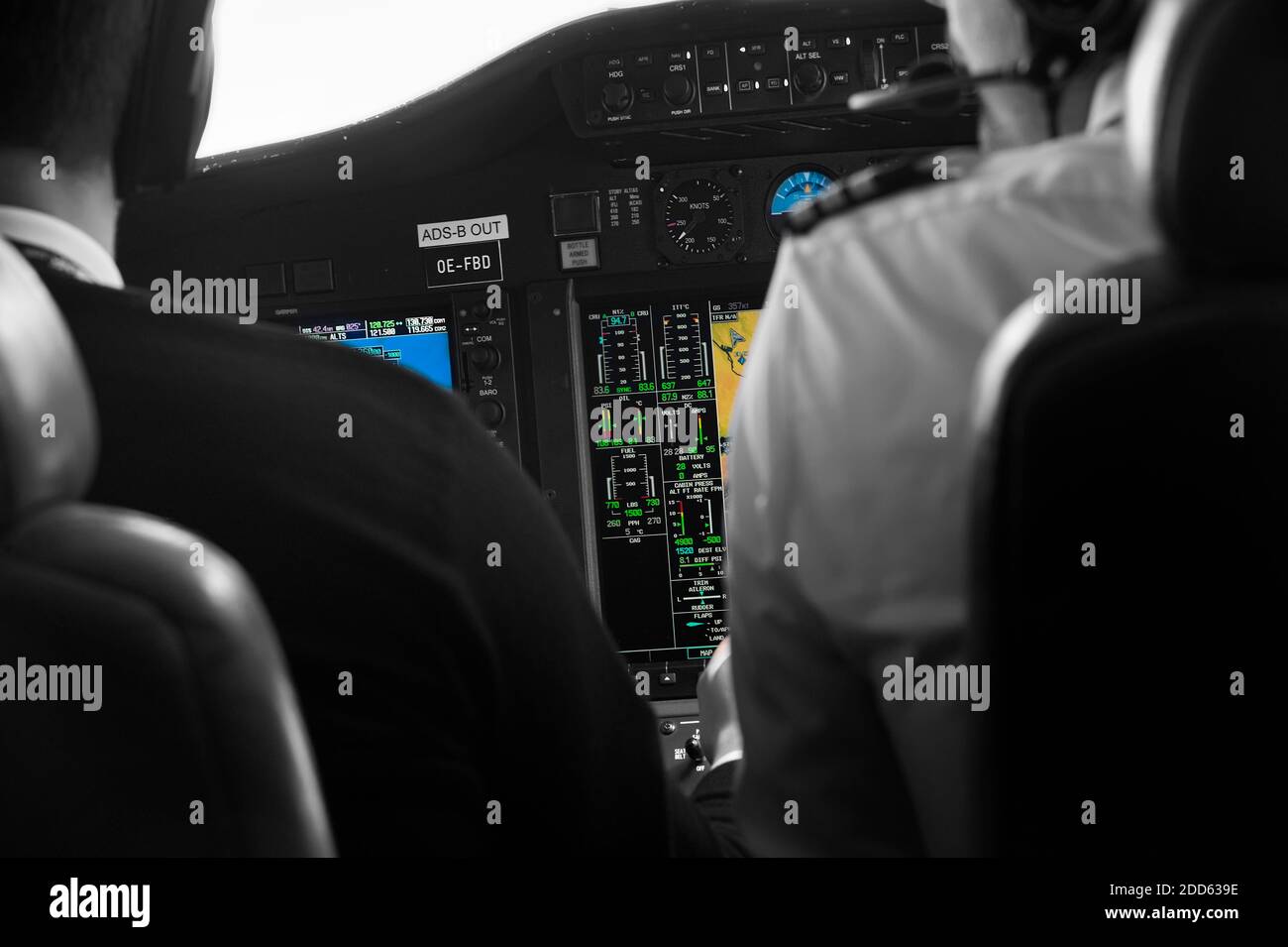 Two pilots sitting in a plane cockpit in front of navigation panel ...
