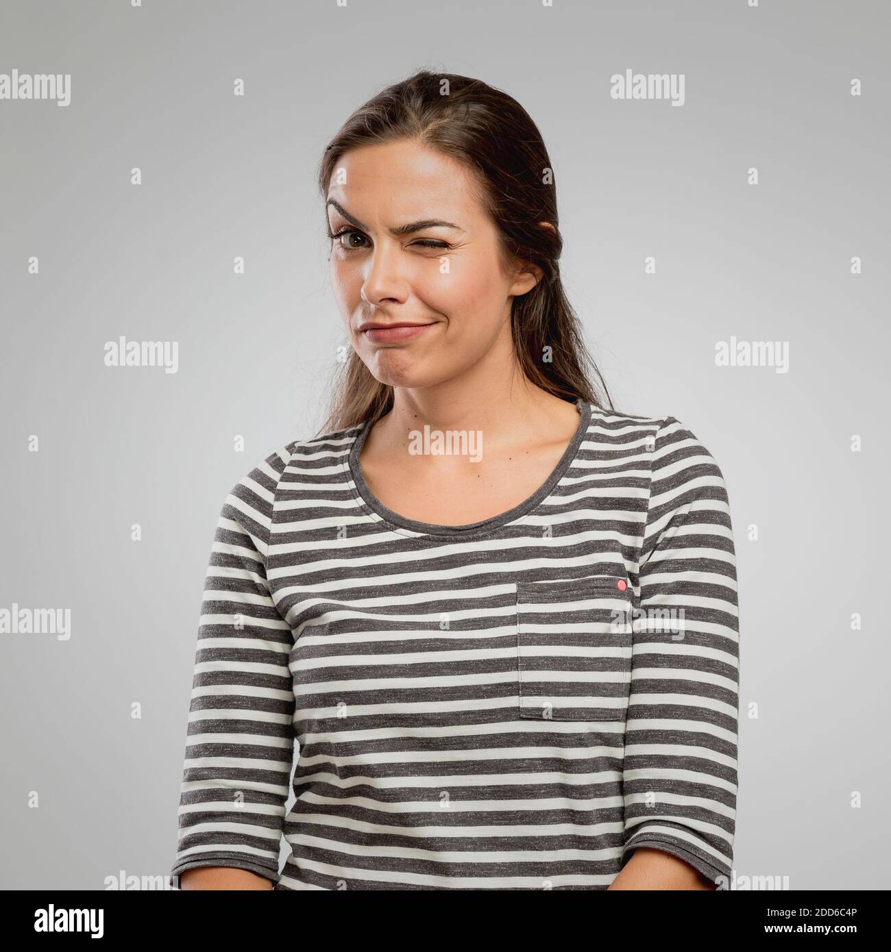 Portrait of a beautiful happy winking, over a gray background Stock ...