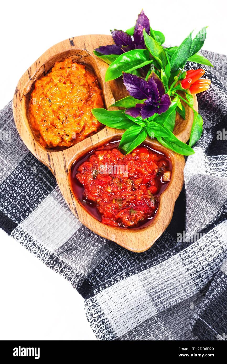 Balkan meze consisting of two types of red pepper spread, bread ...