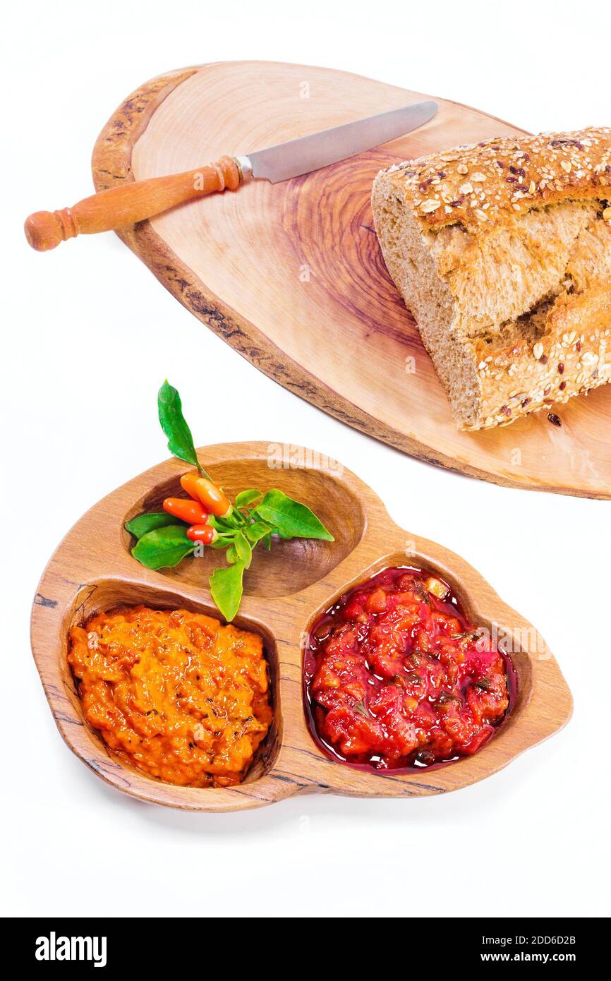 Balkan meze consisting of two types of red pepper spread, bread ...