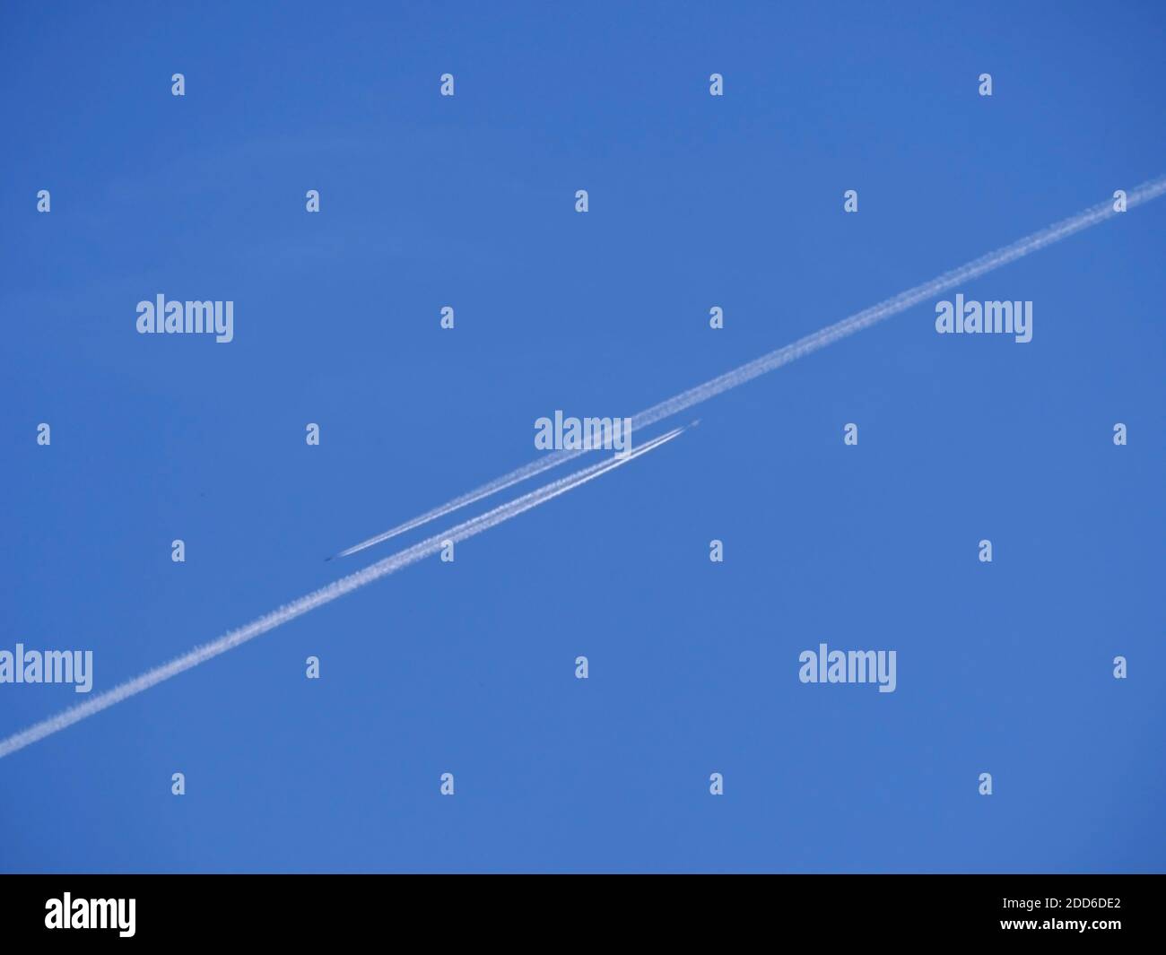 Two planes flying high in the blue sky Stock Photo - Alamy