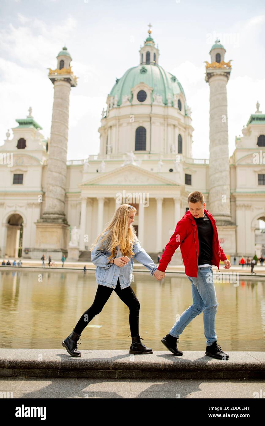 Happy young couple walking by St. Peter's Catholic church in Vienna ...