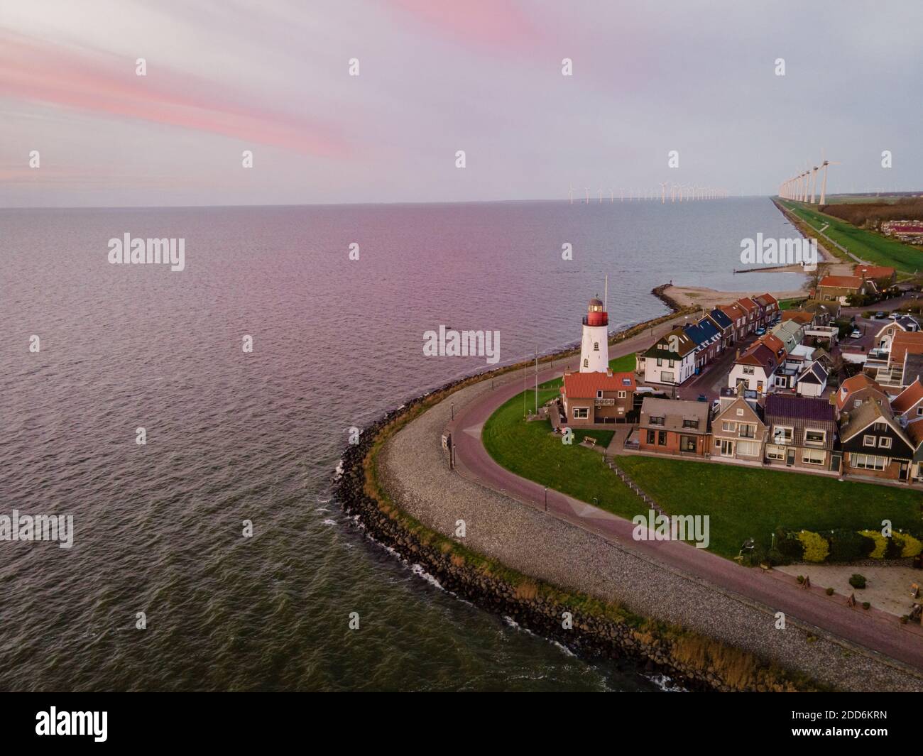 Urk lighthouse with old harbor during sunset, Urk is a small village by ...
