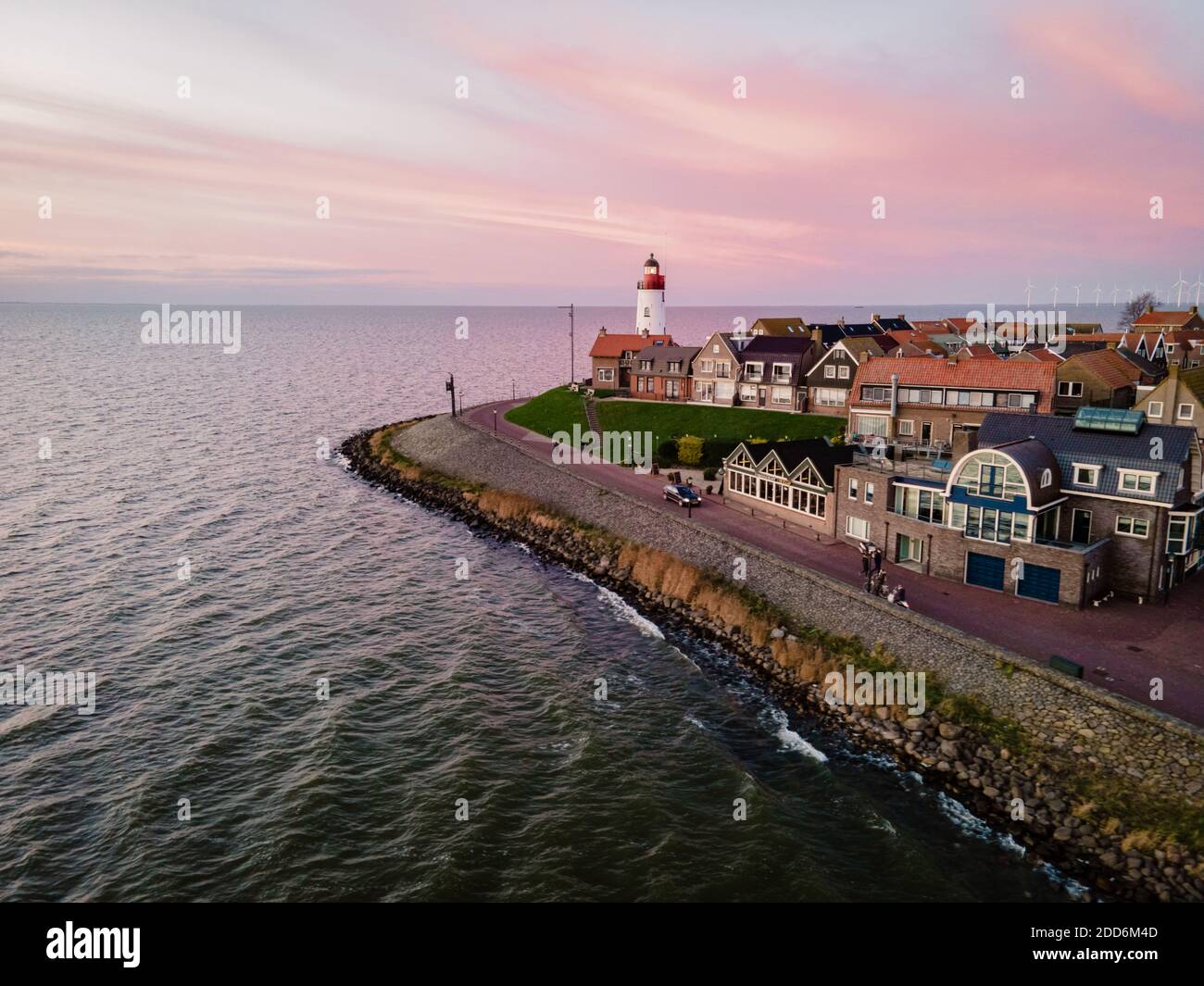Urk lighthouse with old harbor during sunset, Urk is a small village by ...