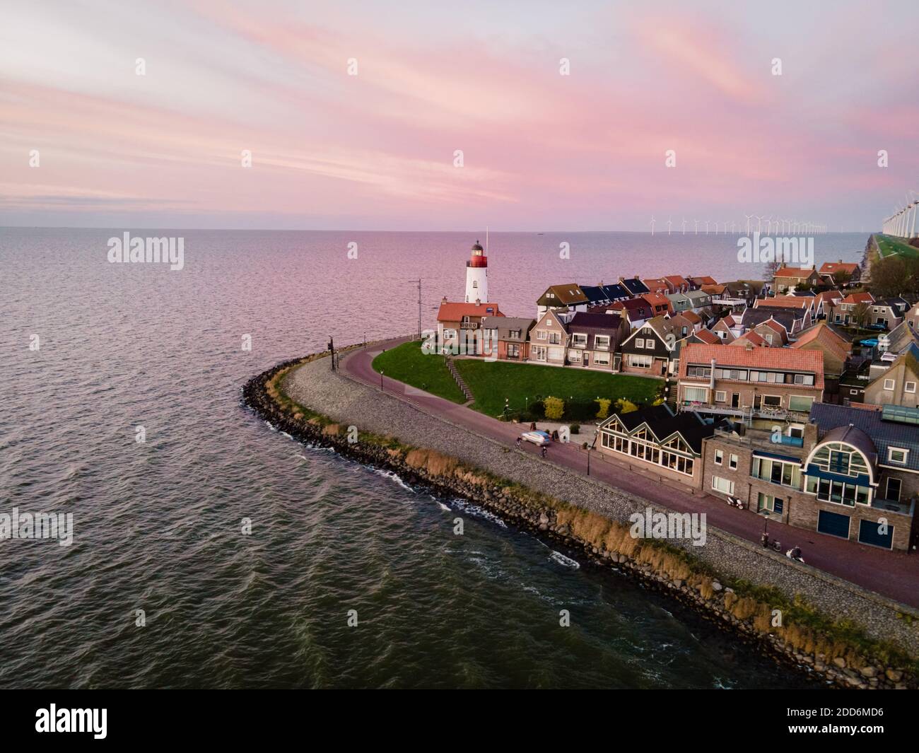 Urk lighthouse with old harbor during sunset, Urk is a small village by ...