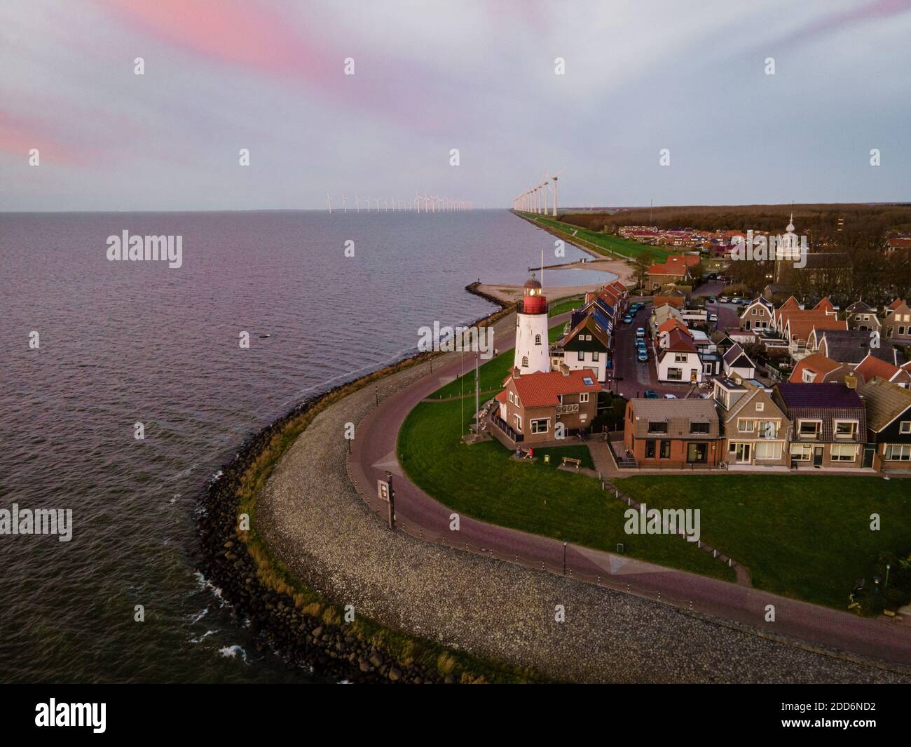 Urk lighthouse with old harbor during sunset, Urk is a small village by ...