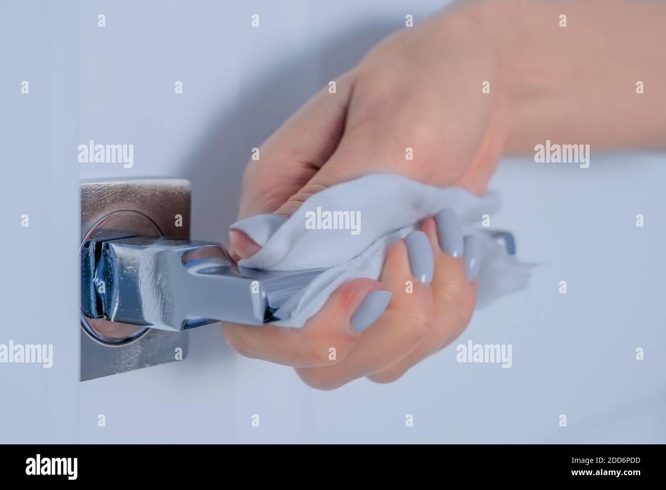 Woman cleaning door handle with wet wipe - disinfection concept Stock ...