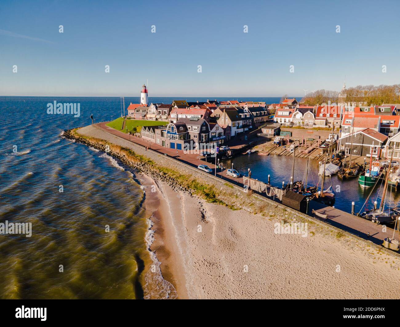 Urk lighthouse with old harbor during sunset, Urk is a small village by ...