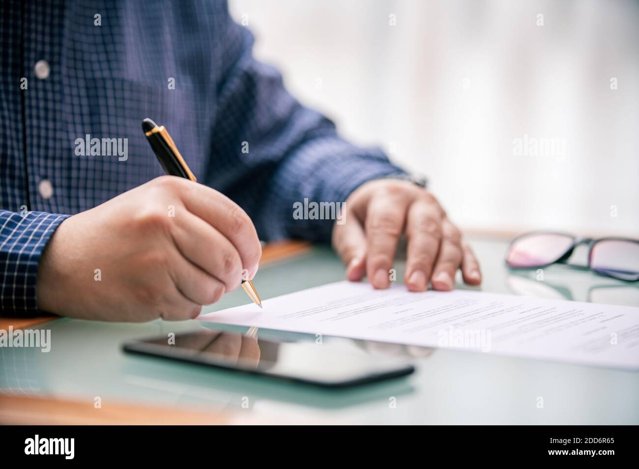 Man in shirt signing document Stock Photo - Alamy