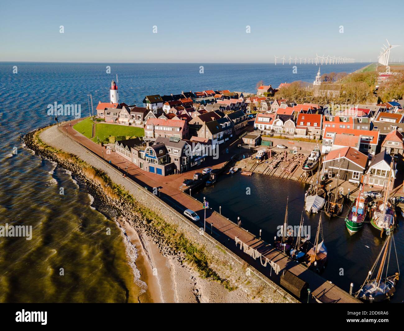 Urk lighthouse with old harbor during sunset, Urk is a small village by ...