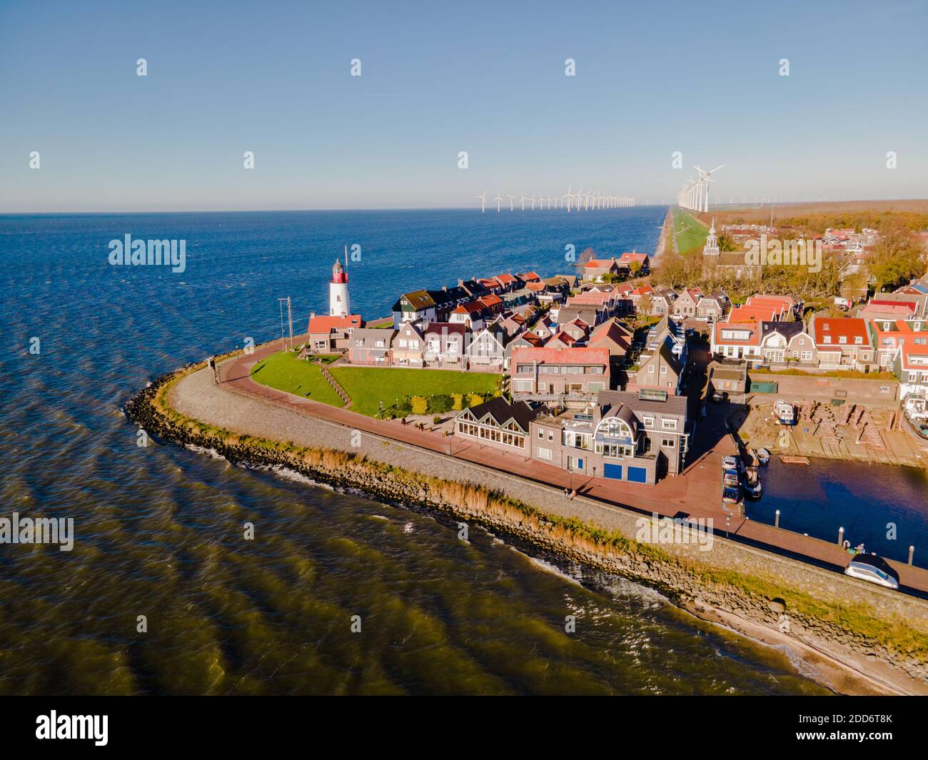 Urk lighthouse with old harbor during sunset, Urk is a small village by ...