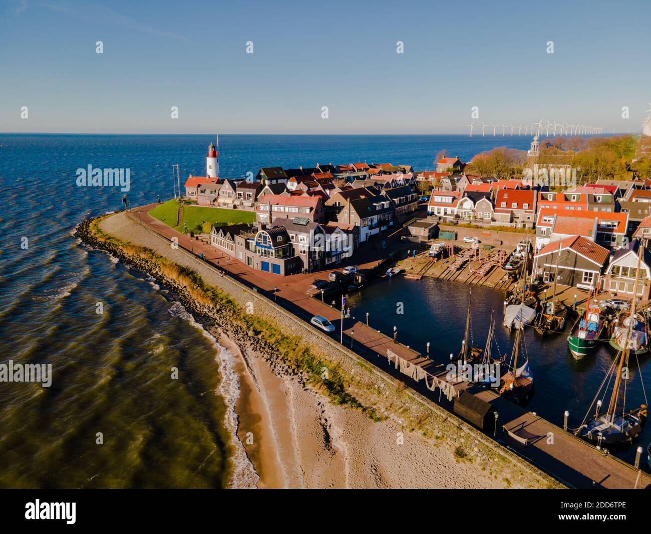 Urk lighthouse with old harbor during sunset, Urk is a small village by ...