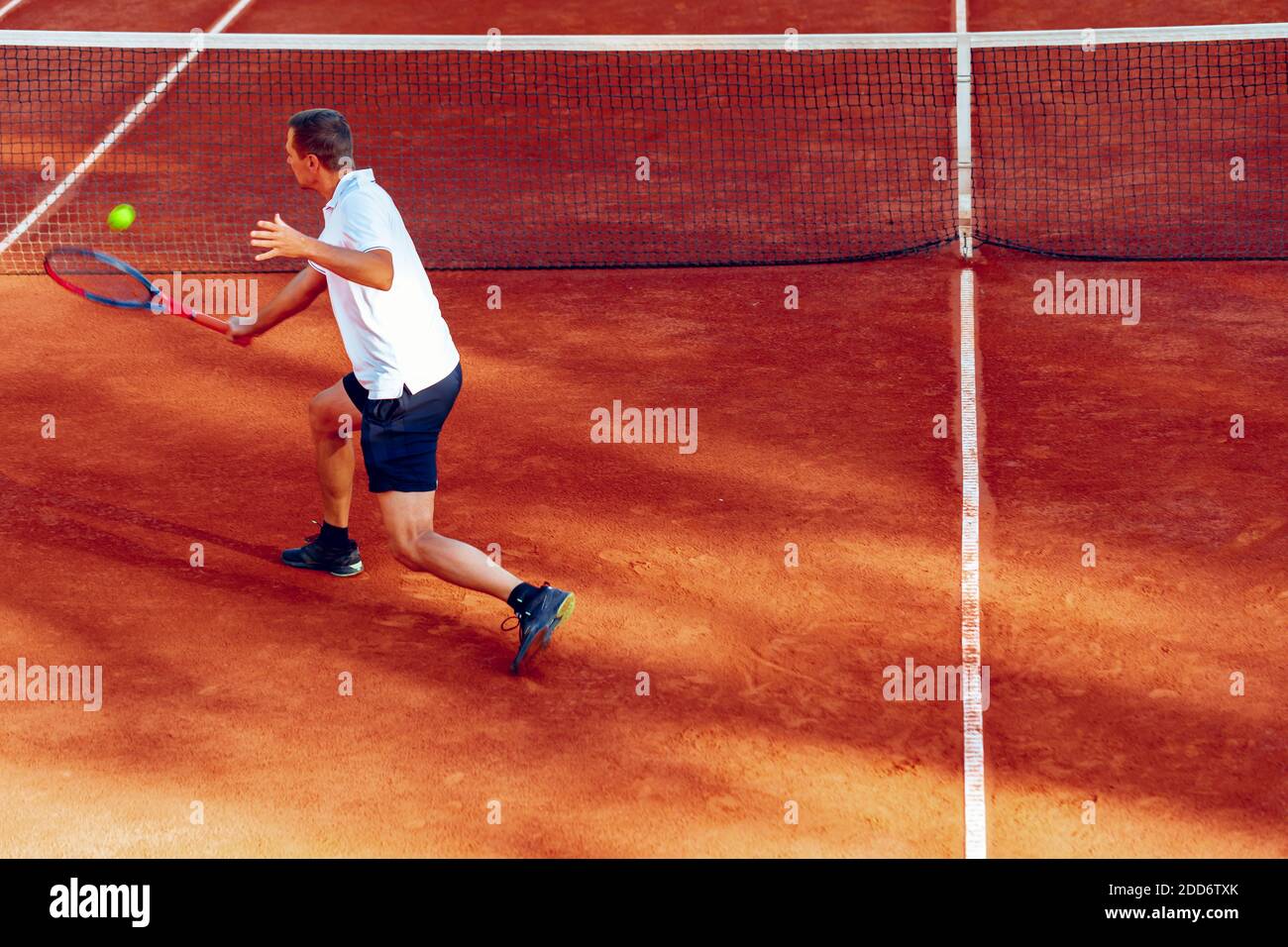 Back view of a man playing tennis on tennis court Stock Photo - Alamy