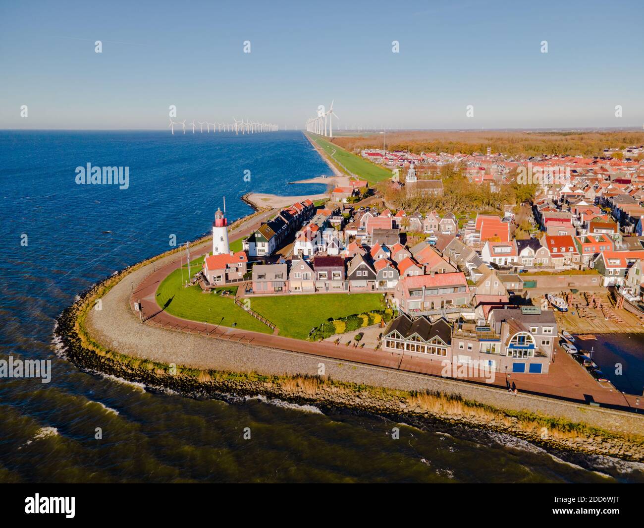 Urk lighthouse with old harbor during sunset, Urk is a small village by ...