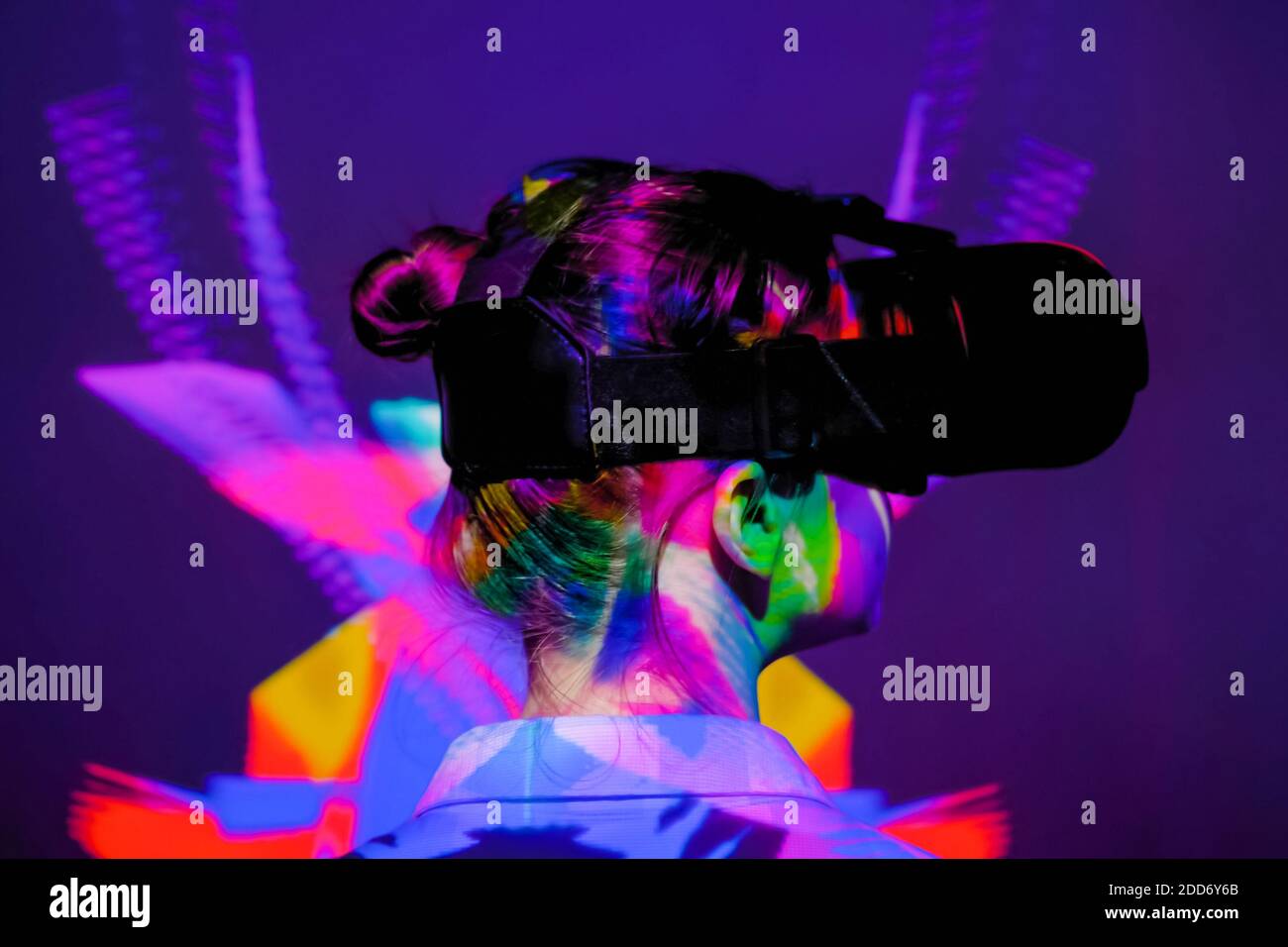 Back view: woman using virtual reality headset at dark interactive VR ...