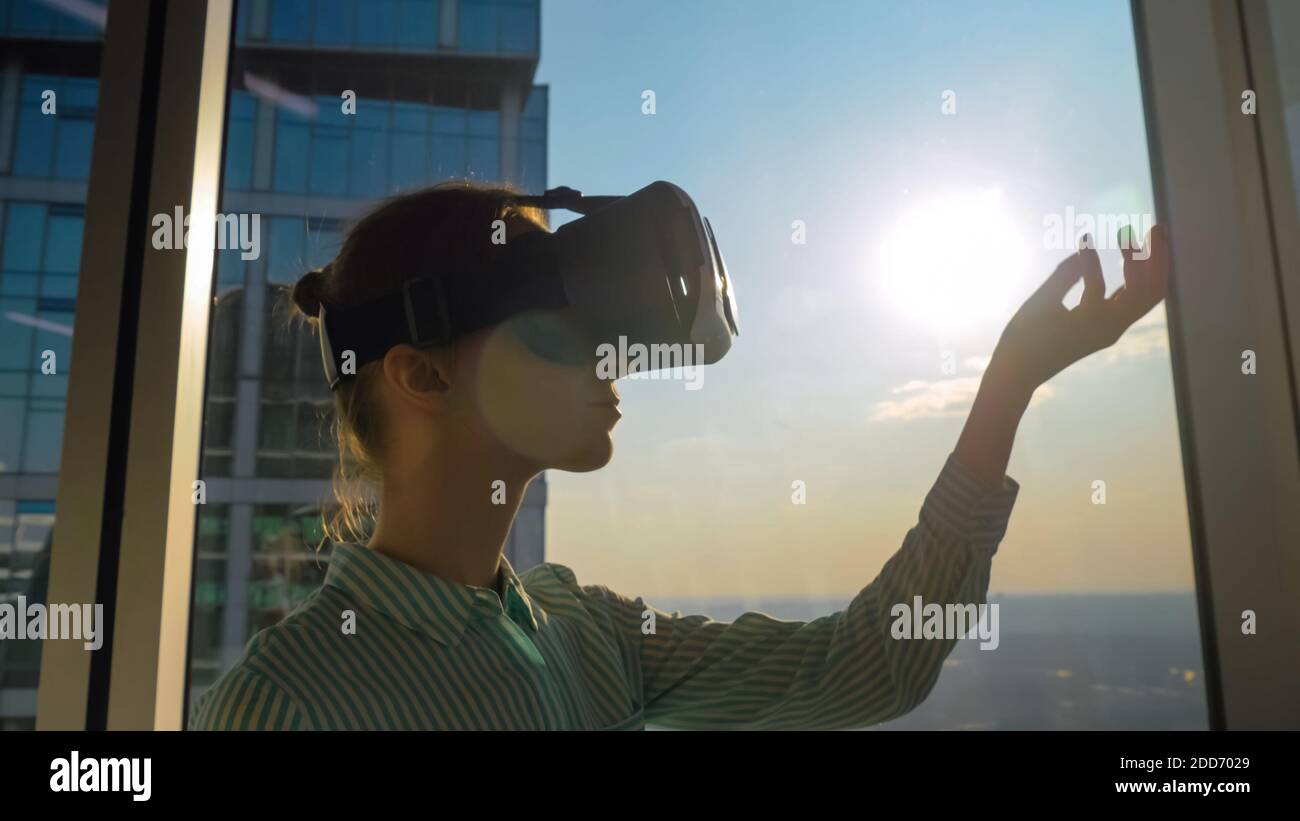 VR concept - young woman using virtual reality headset against ...