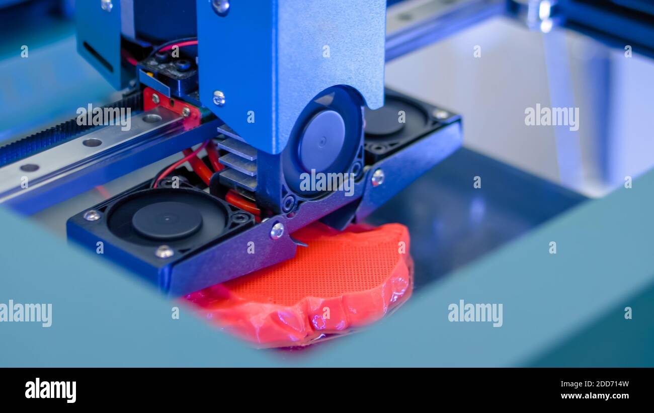 Automation 3D printing machine printing red plastic model at exhibition ...