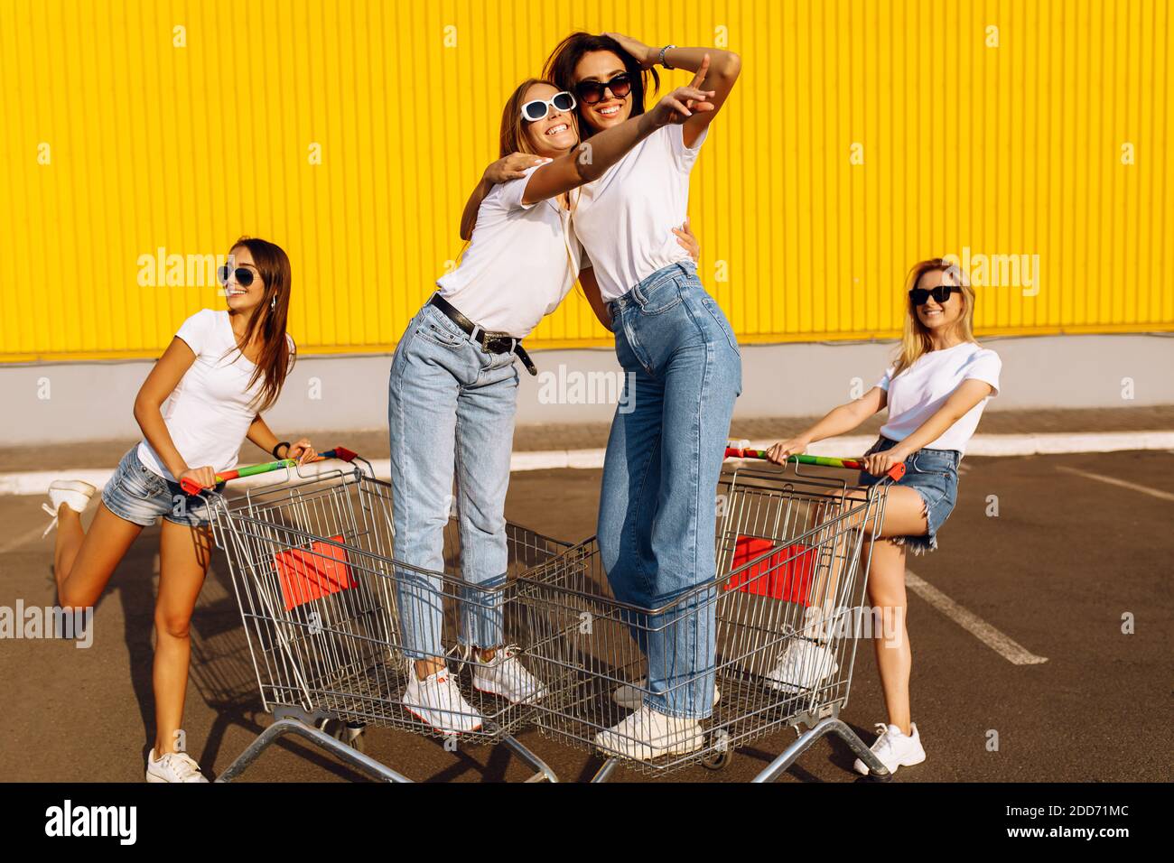 happy young people having fun on shopping carts, young people riding ...