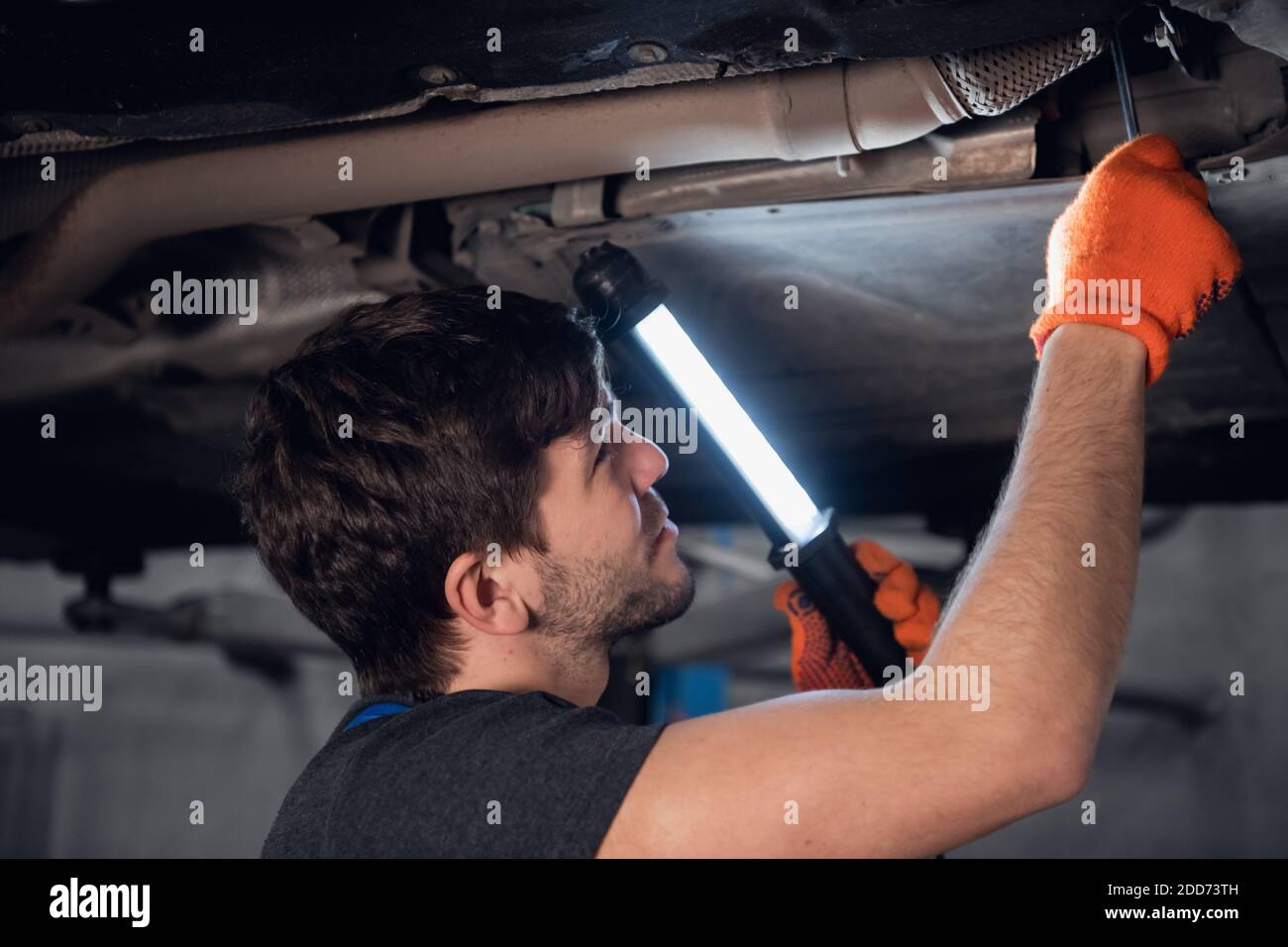 Man in uniform using a flashlight checks the bottom of the machine ...
