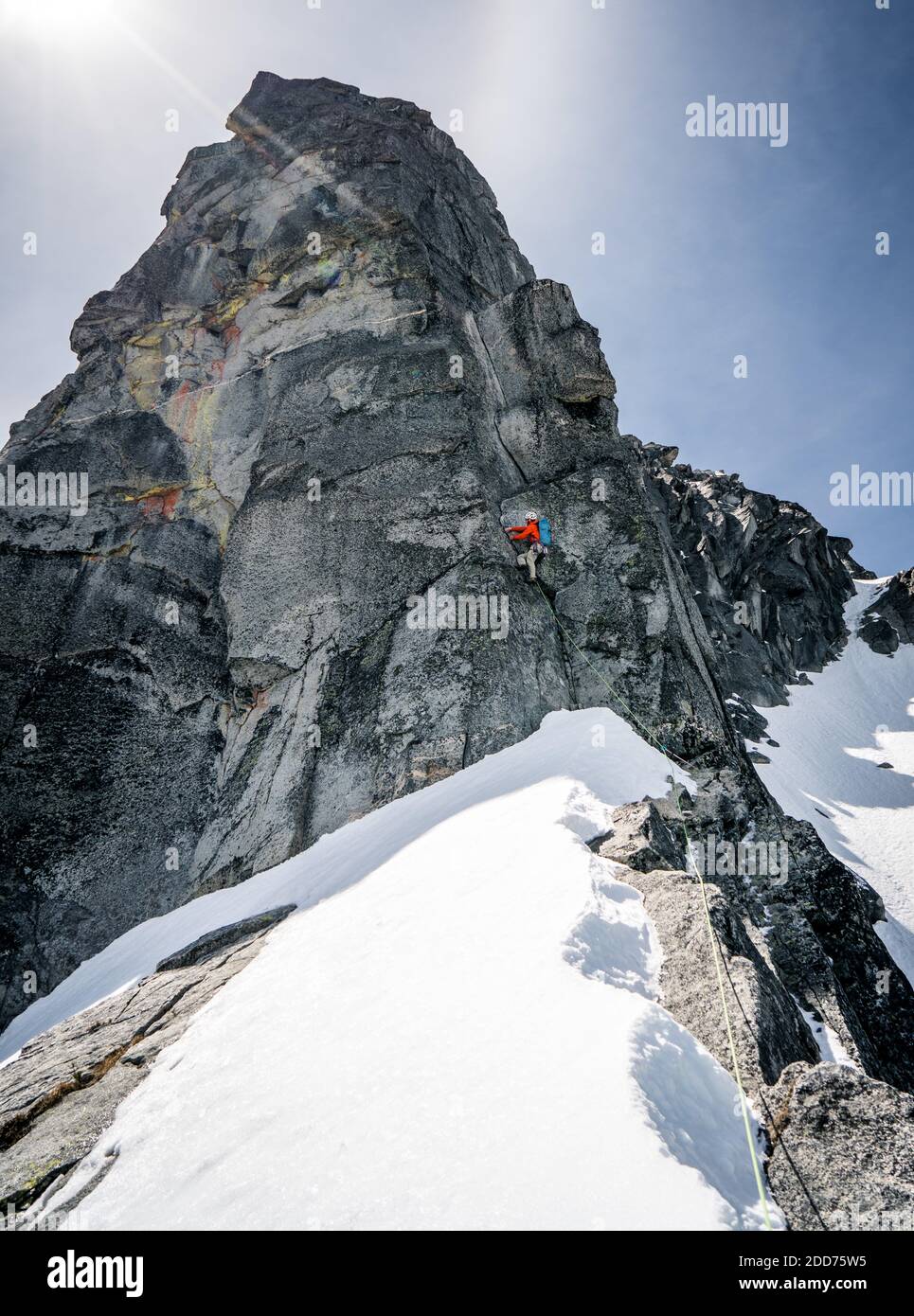 Male rock climbing giant peak in snow Stock Photo - Alamy