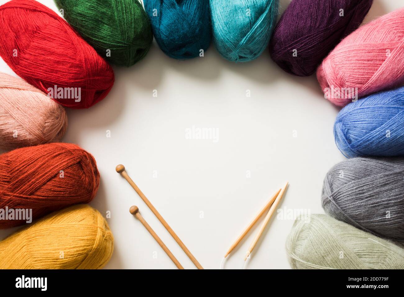 Colored yarn balls and knitting needles on white Stock Photo - Alamy