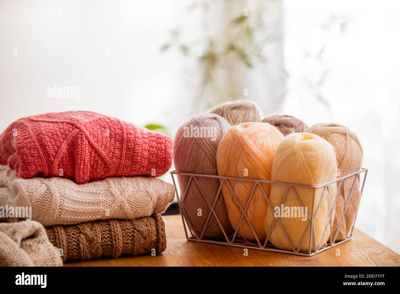 Cozy knitted sweaters with balls of yarn in the living room Stock Photo ...