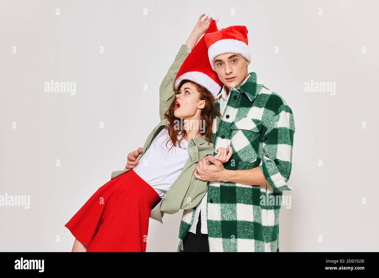 Cheerful drunk woman in the arms of a man Christmas holiday studio ...