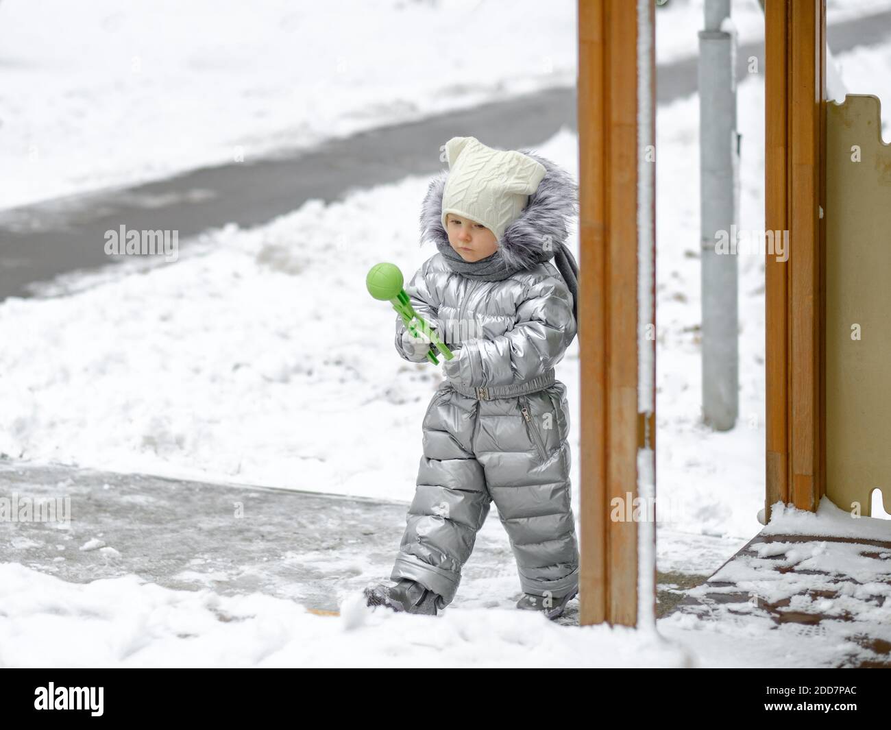 Happy child during the day on a winter walk. A cheerful little girl in ...
