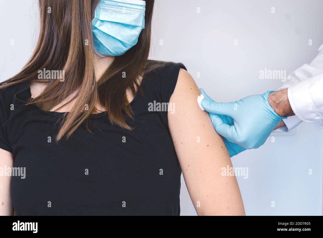 Doctor holding cotton wool on girl's arm after injection Stock Photo ...