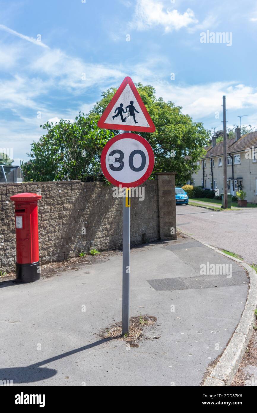 A post on a typicla residential street corner with British road signs ...