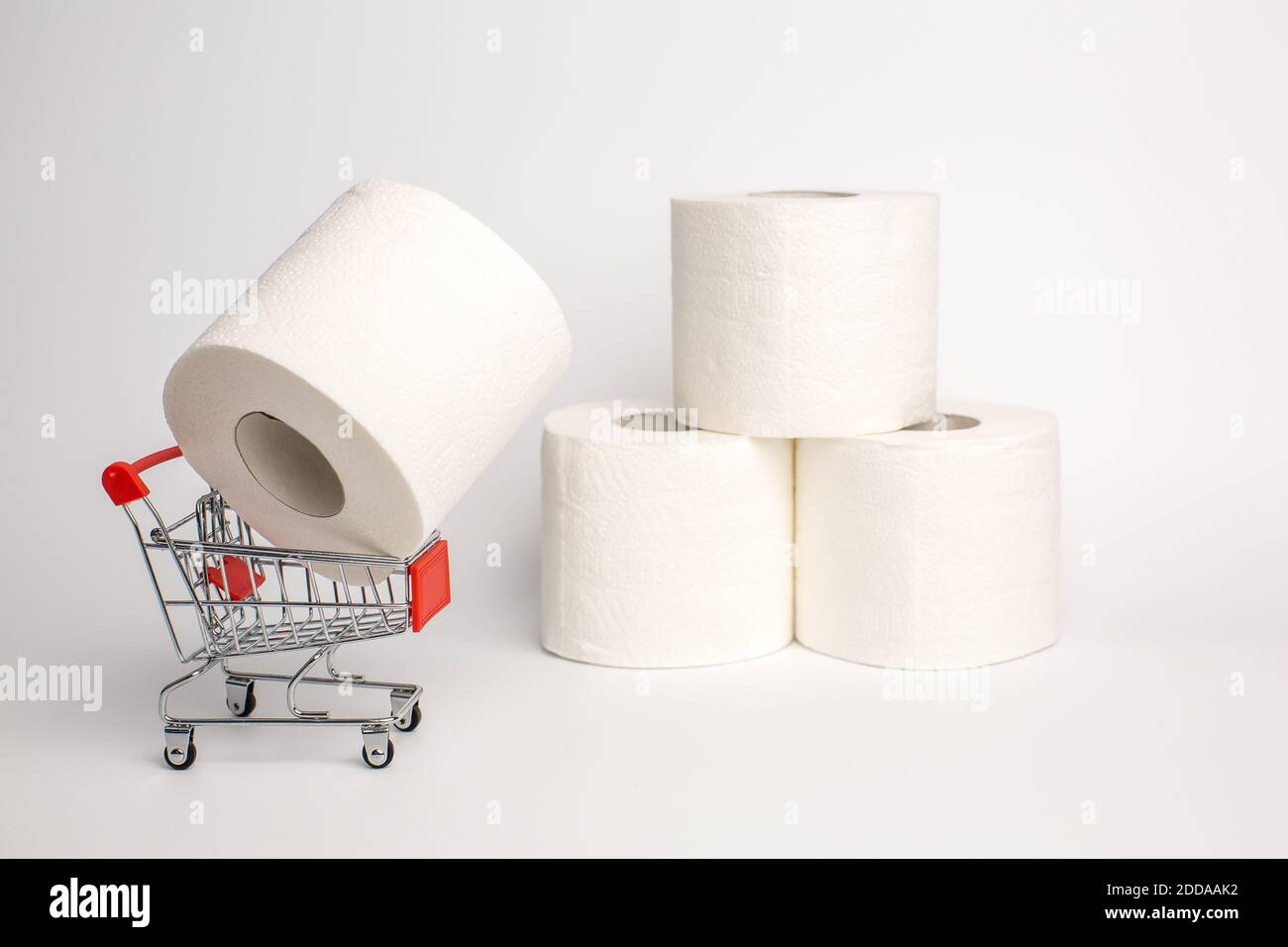 Roll of toilet paper in a toy trolley on a white background. Close-up ...