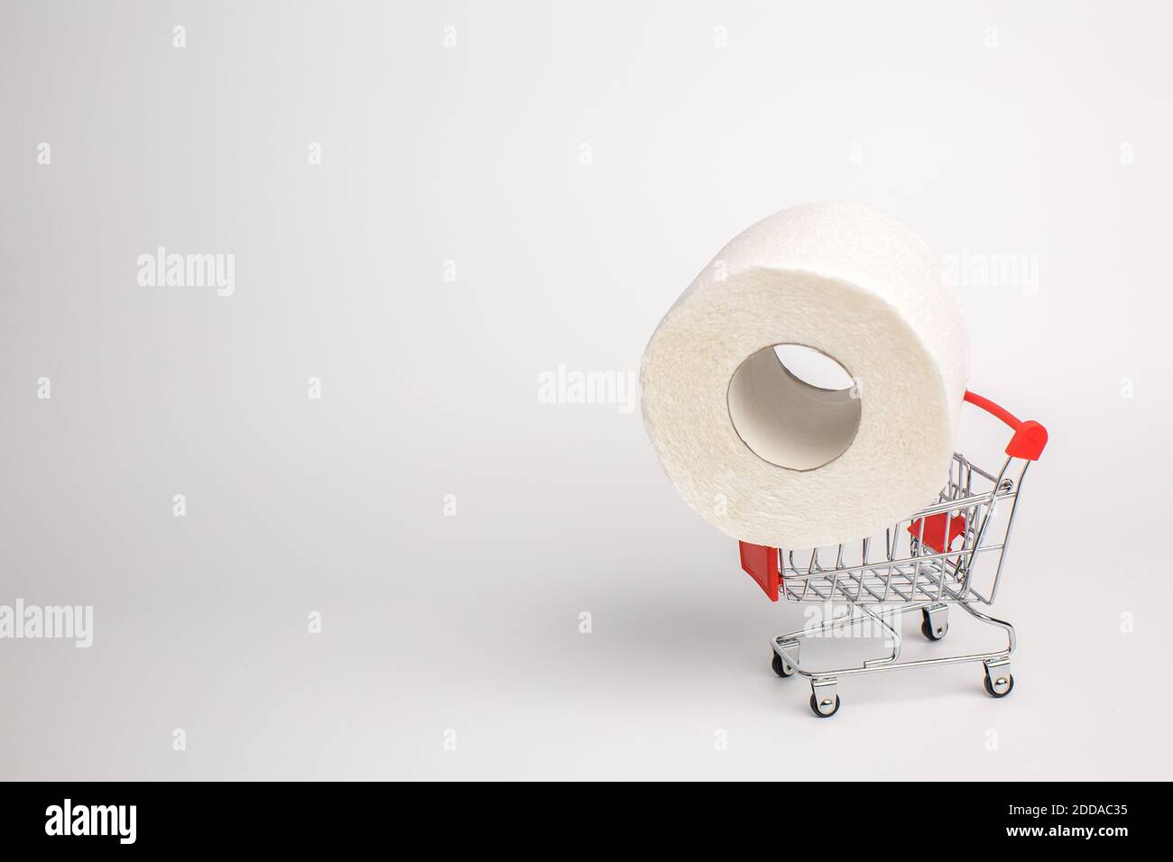Roll of toilet paper in a toy trolley on a white background. Close-up ...