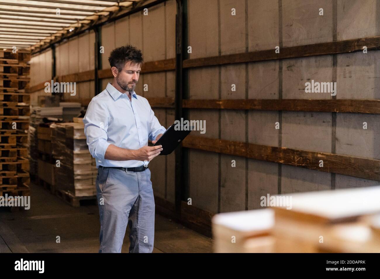 Male inspector with digital tablet loading material while standing in ...